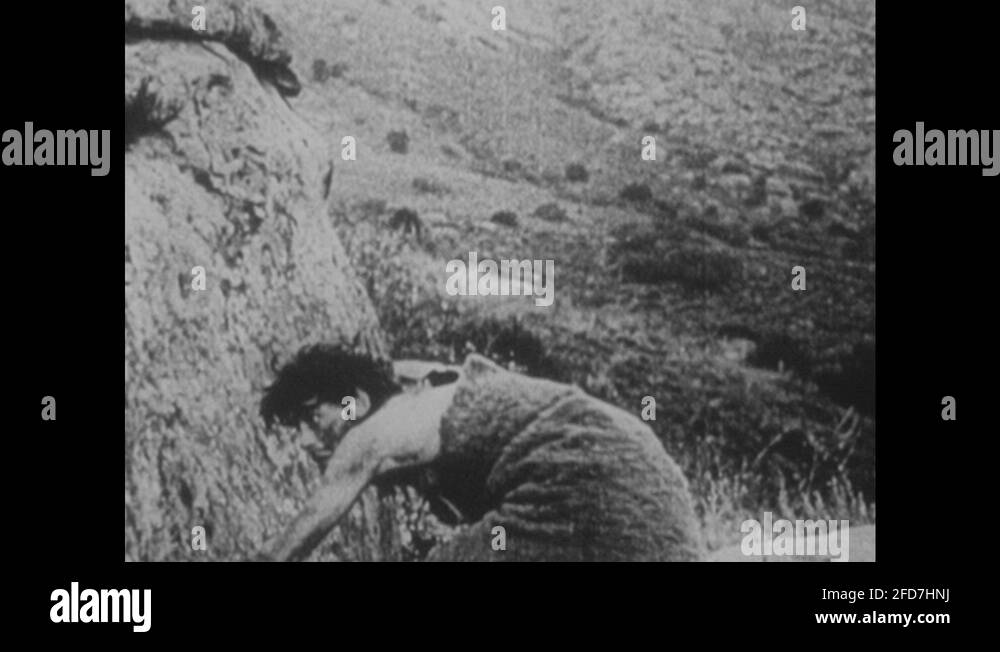 1910s: Man hiding behind rock. Man chasing woman, grabs woman. Man runs ...