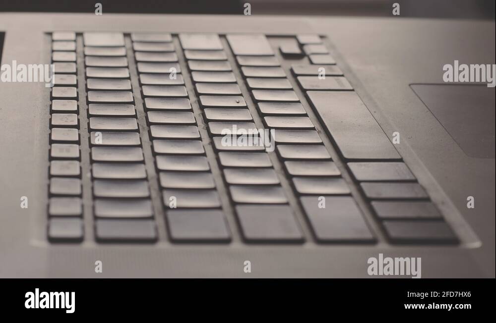 Typing code on a dusty Macbook pro keyboard. Lateral view with soft ...