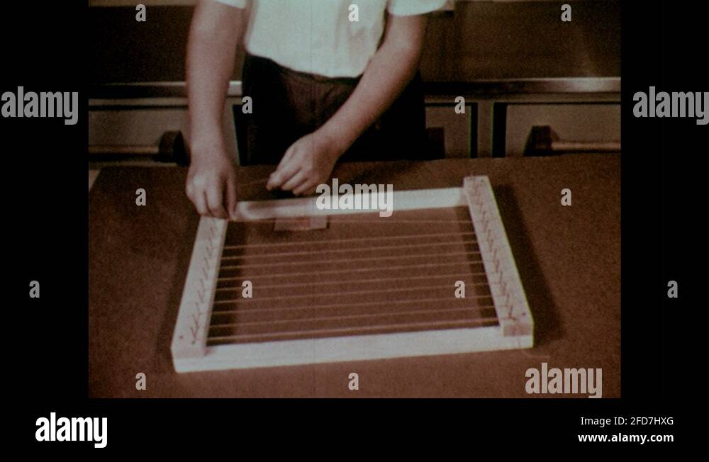 1950s: Boy nears completing winding the warp string around the frame of ...