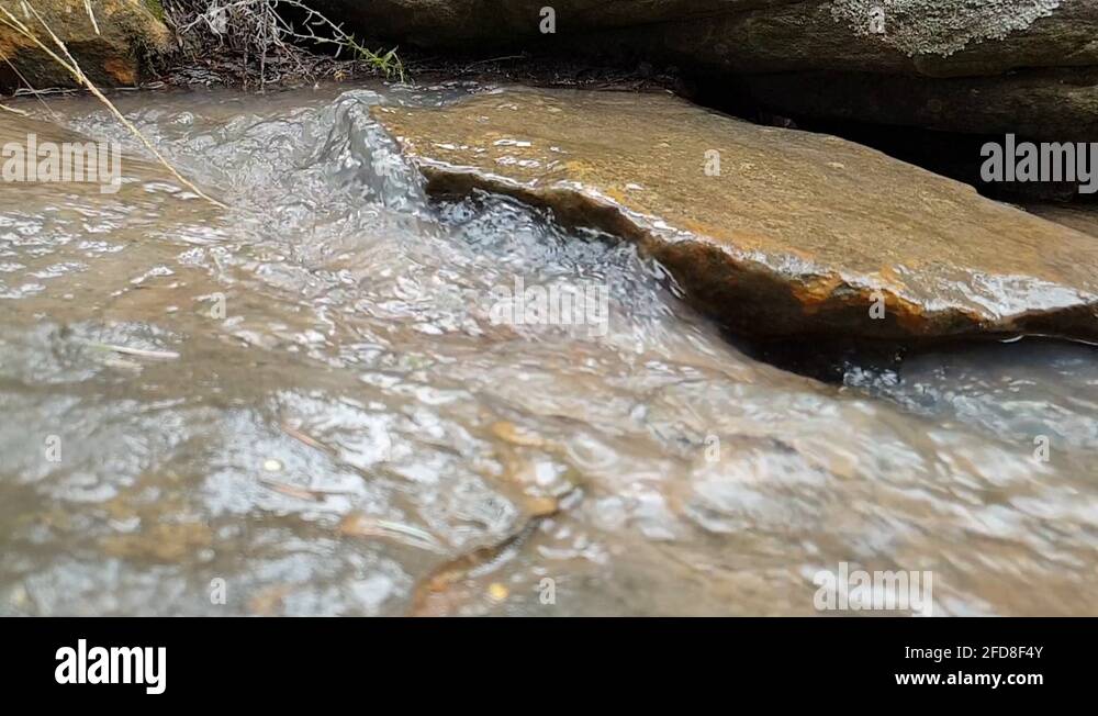 flowing mountain spring water stream running down huge sandstone slabs ...