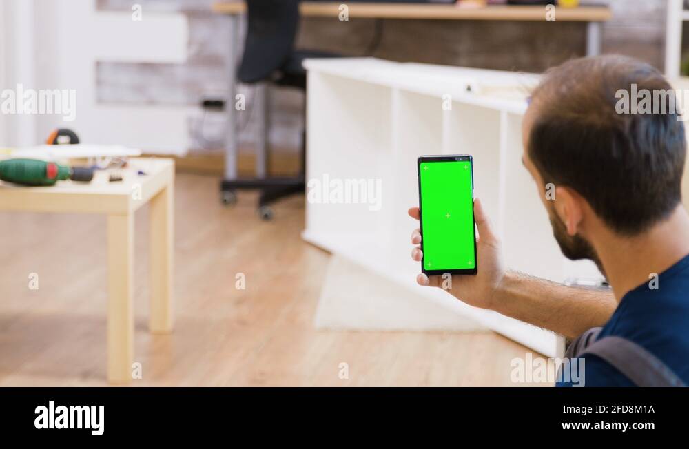 Back view of male worker holding phone with green screen Stock Video ...