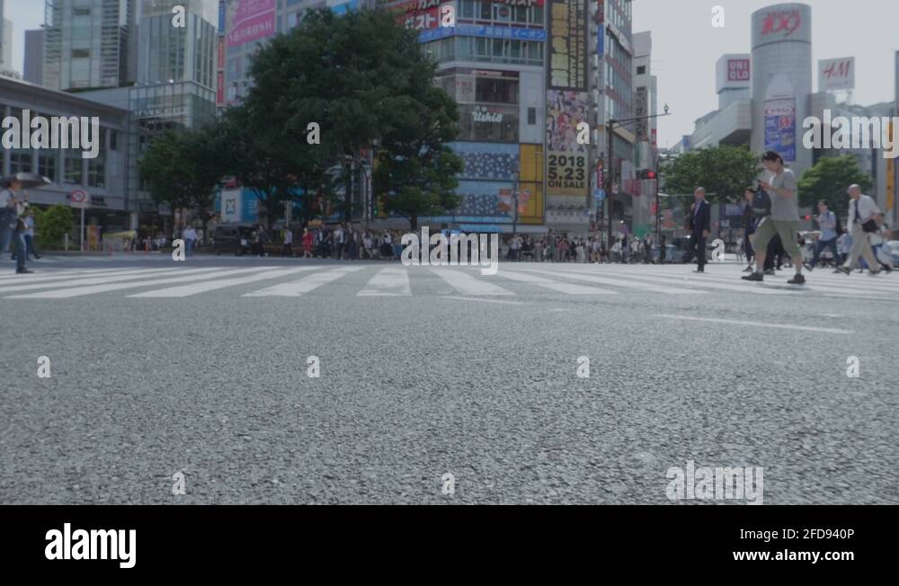 a huge intersection in Tokyo, Japan where people cross the street on a ...
