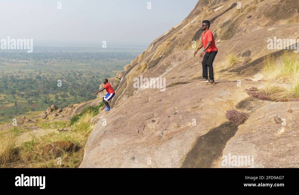 Two African men performing squats on the side of a breathtaking granite ...