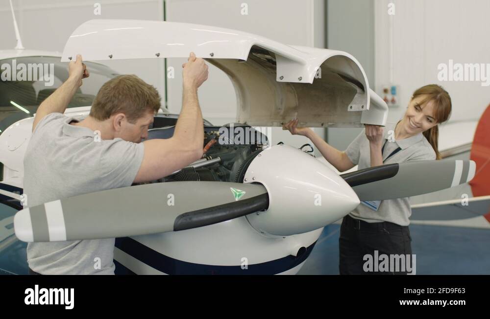 Engineers placing cover on engine of airplane in hangar Stock Video ...