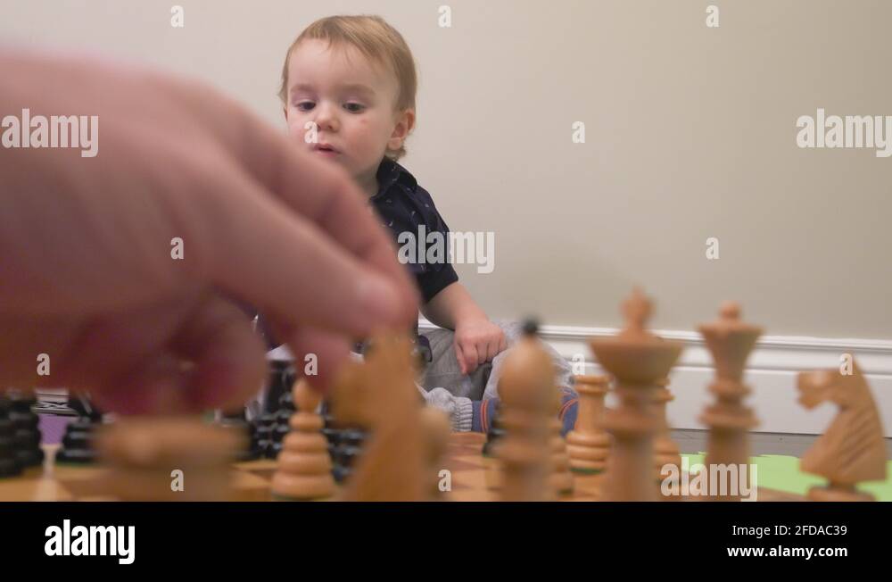 Curious baby boy playing a game of chess with his dad Stock Video ...