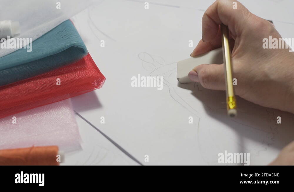 Dressmaker is drawing a fashion sketch. Close up of the hands with ...