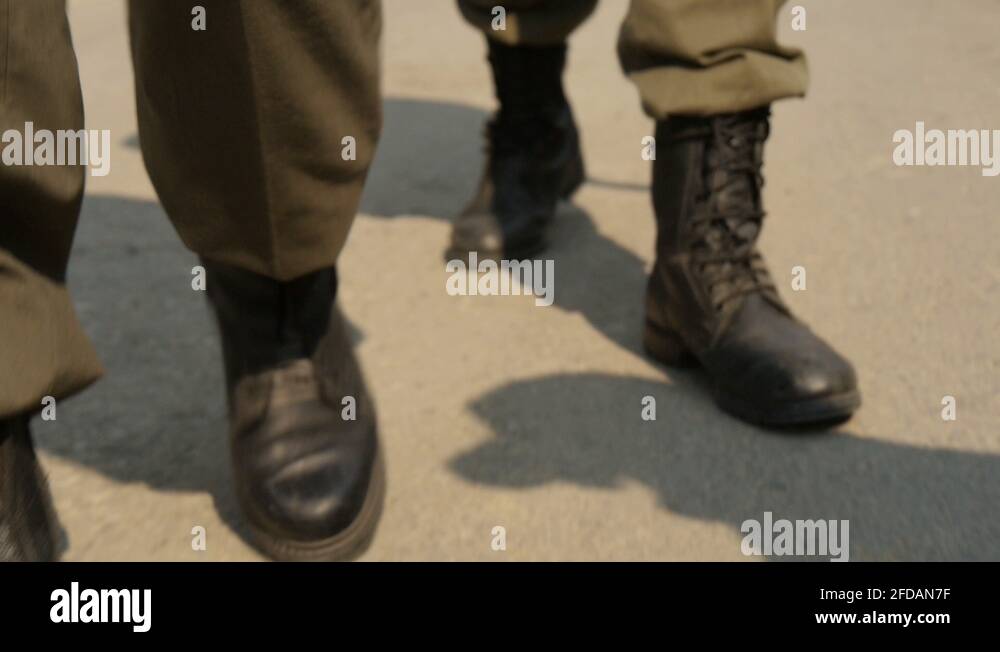 Low angle close-up of soldiers walking towards camera wearing military ...
