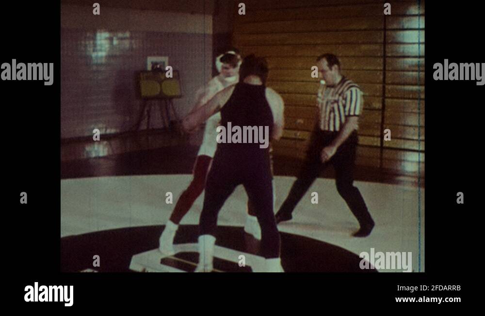1970s: Two wrestlers face off on mat. Wrestler tries to grab opponents ...