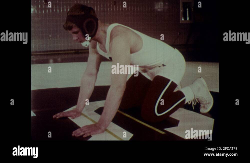 1970s: Wrestler is on hands and knees on mat. The placement of wrestler ...