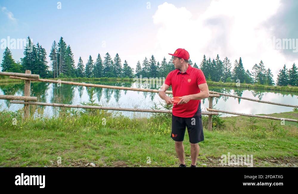 Male disc golfer frisbee golf player completes a toss in front of a ...