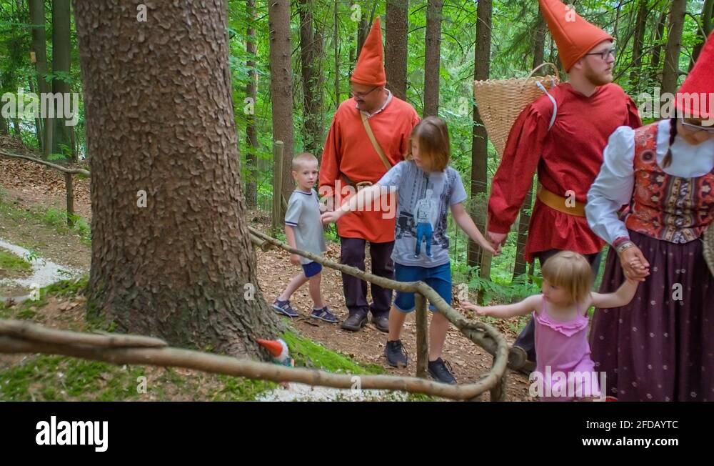 Adults and children walk along path in woods dressed as dwarf Stock ...