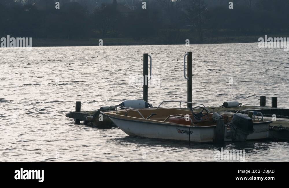 Rowing boats tied up to a dock during the cold winter months in Hornsea ...
