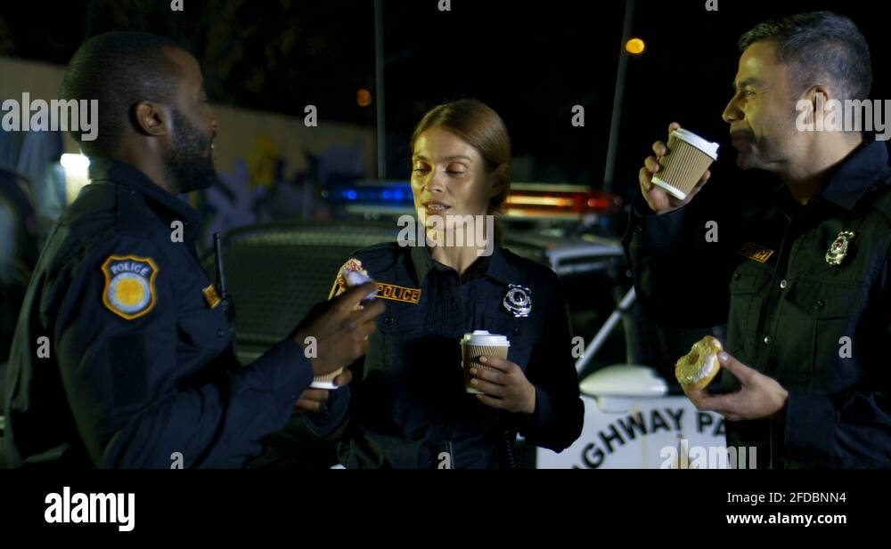 Multiethnic male and female police officers talking cheerfully and ...