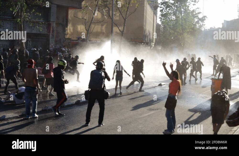 Armored riot police vehicle uses fire hose to spray water and scatter ...