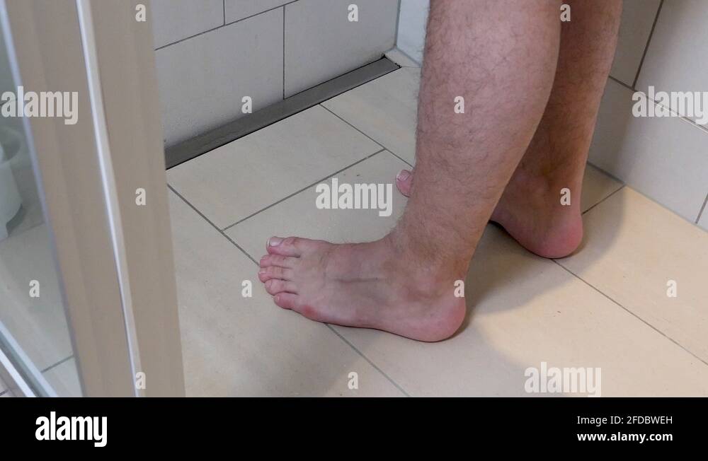 Drops of blood falling on the feet and legs of a man standing barefoot ...