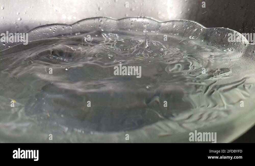 Faucet drainage hole in stainless kitchen sink with water dripping and ...