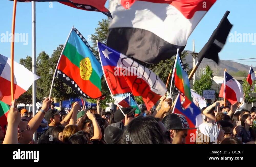 People protest and wave the mapuche and black chilean flag during a ...