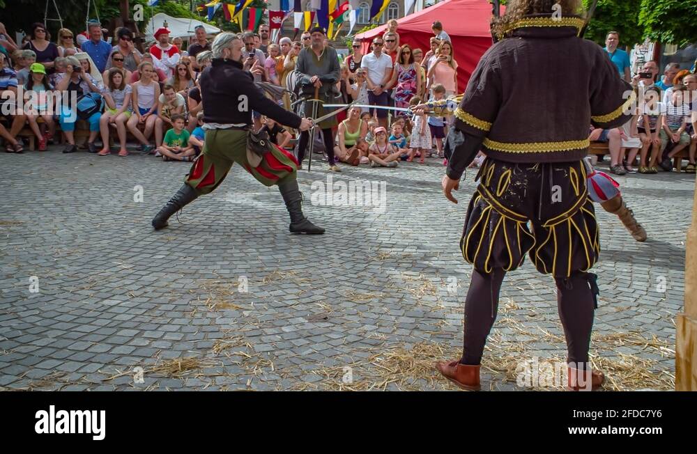 Spectators enjoying the sword fight between two men at the medieval ...