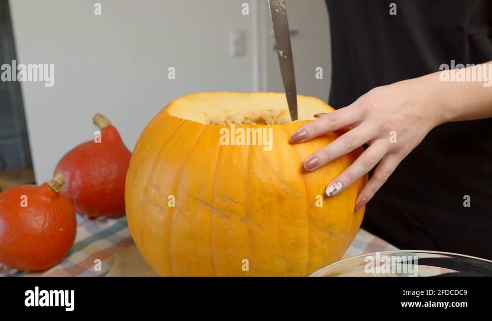 A Lady Scraping The Guts And Seeds Inside The Pumpkin With A Sharp ...