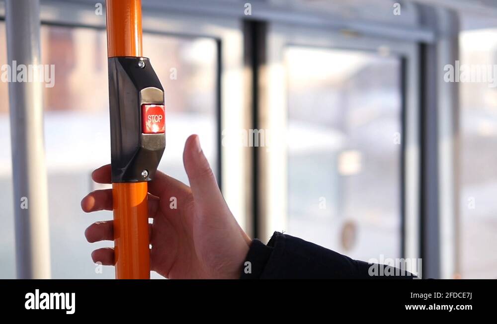 Girl presses bus stop bell on the bus in slow motion. Red stop ...