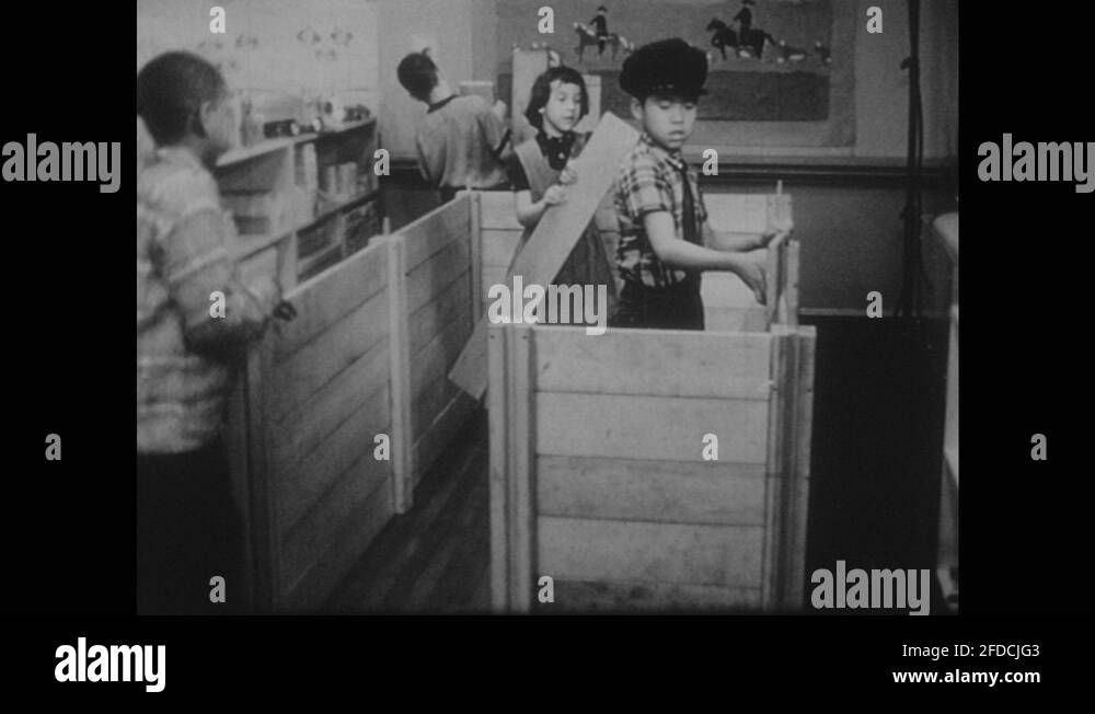 1960s: Kids building playhouse walls with wood planks. Boys attaching ...