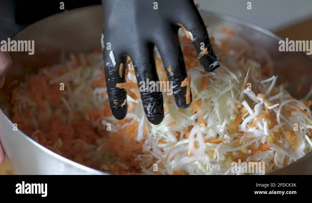 Mixing and tossing crisp cabbage and carrots into a homemade coleslaw ...