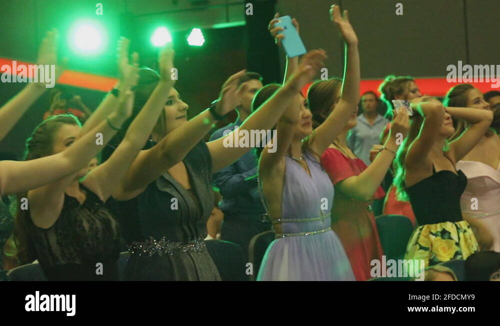 Jubilant crowd of young people raises and waves their hands Stock Video ...