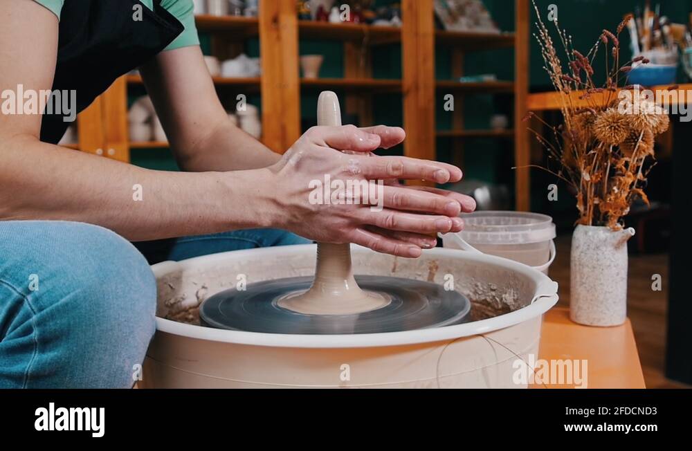 Pottery craftsmanship - a man forming piece of clay in longer shape ...