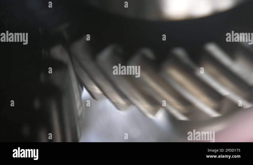 Rotating teeth of two large cogs working aslant in a contemporary car ...