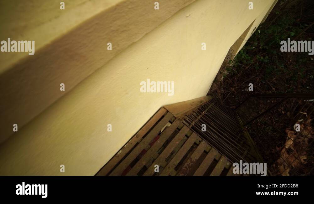 Slow exterior pan and roll up, FPV looking down a set of exterior ...