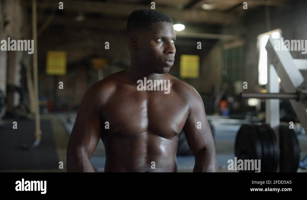 Shirtless African American man rests while kneeling in MMA gym Stock ...