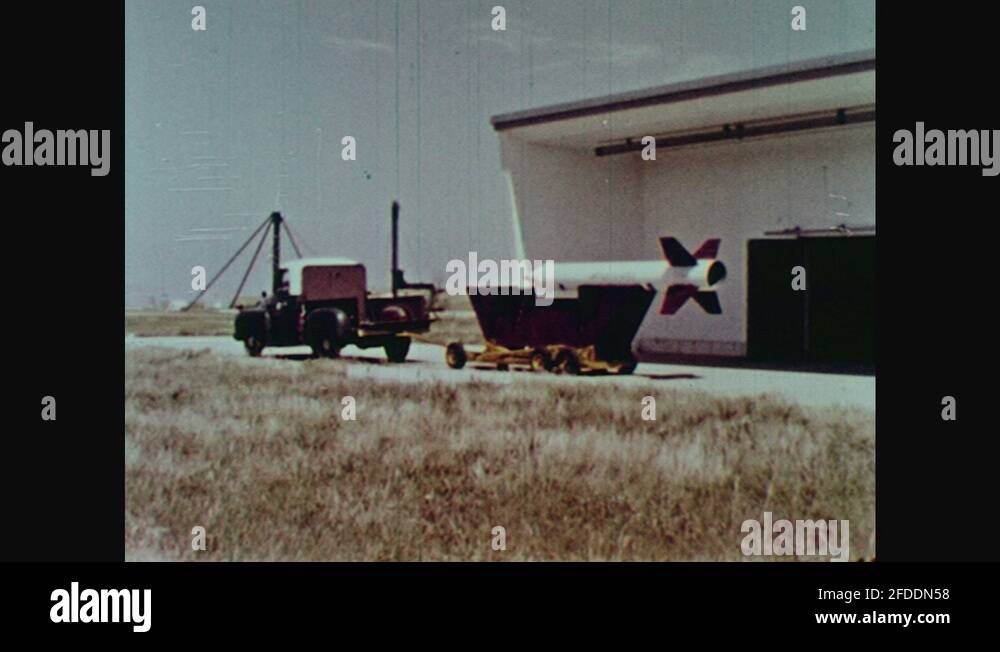1960s: Truck tows cart carrying rocket on it. Rocket on cart being ...