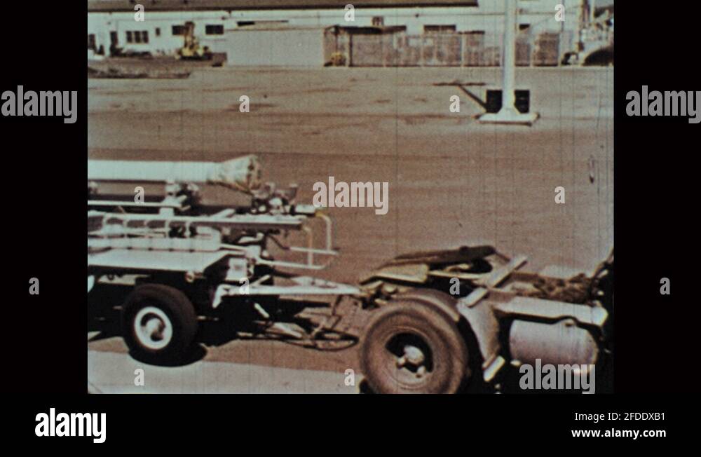 1960s: Rocket is pulled by a truck on a trailer. Crane moves rocket on ...