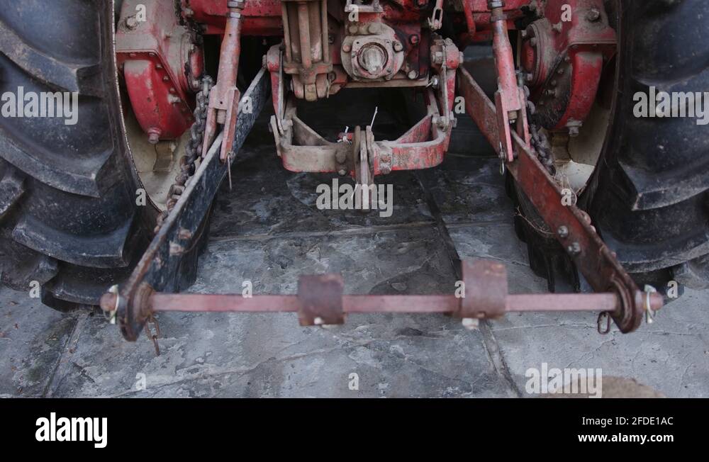 Backside of an old rusty red tractor parked. Tilt up camera Stock Video ...