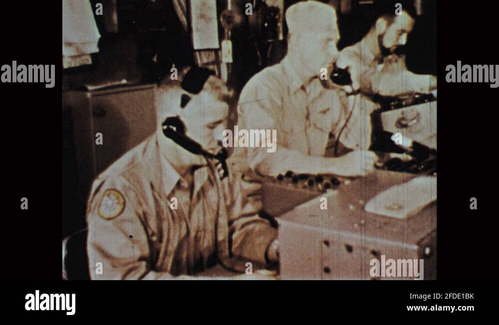 1960s: Control room workers. Rocket is readied for launch. Stopwatch ...
