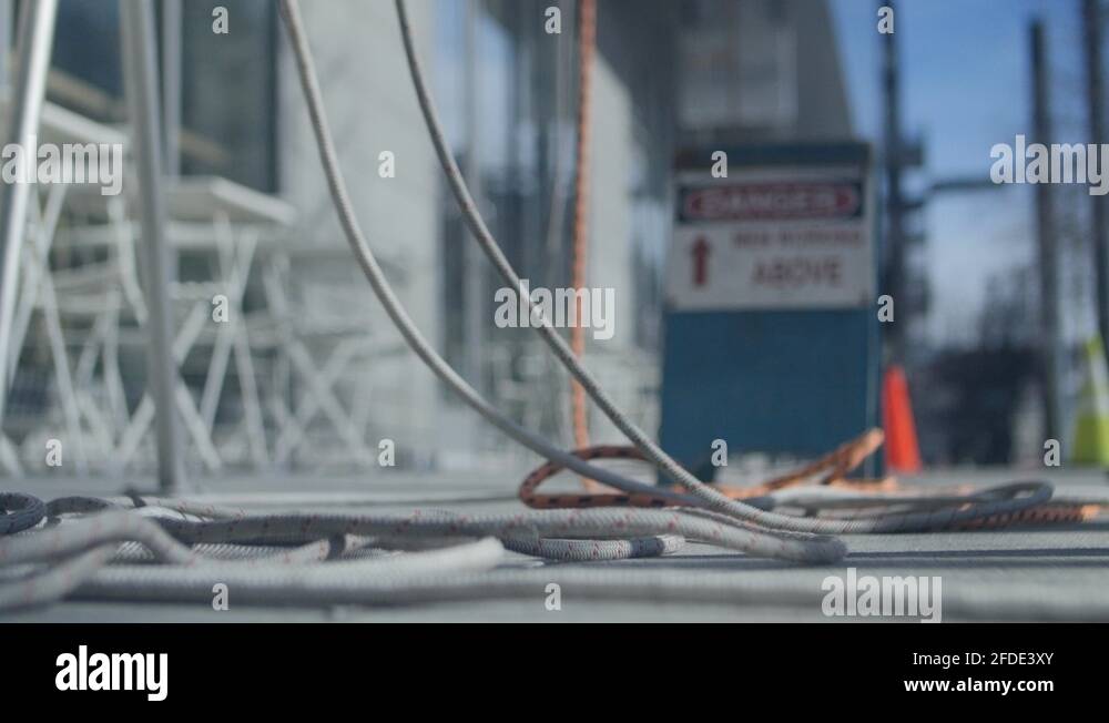 Rack focus of safety ropes and warning sign for high rise window ...