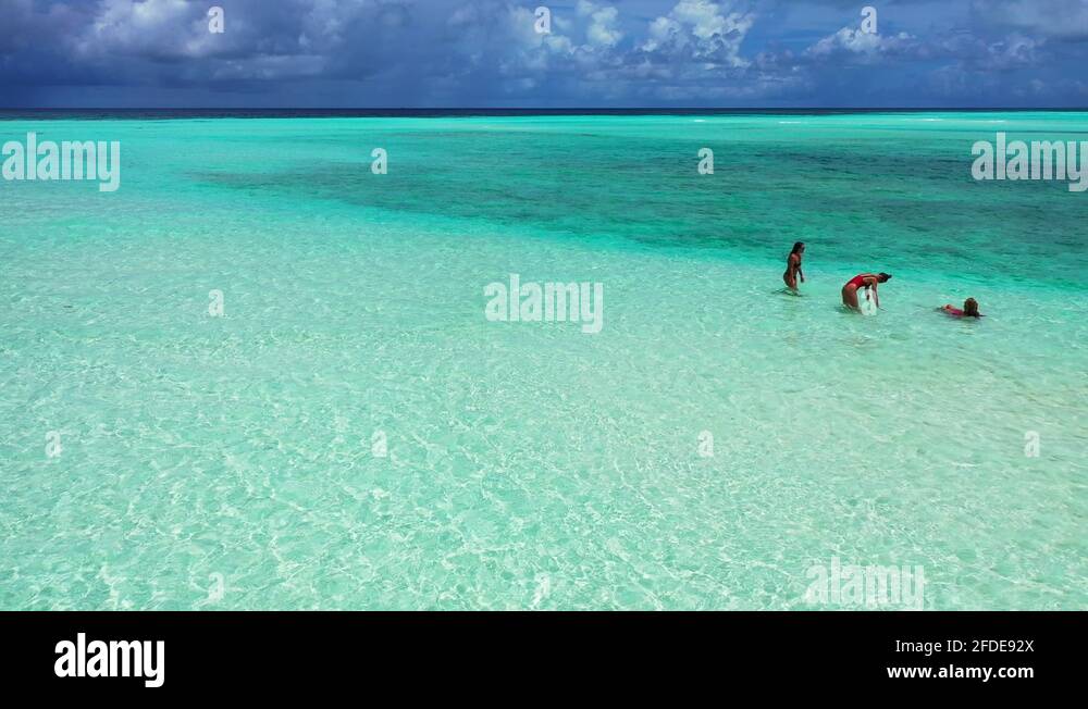 Tree attractive young bikini girls swimming in the endless crystal ...