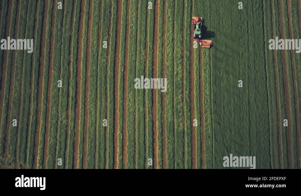 Farming and ploughing fields in spring with tractor. Top down aerial ...