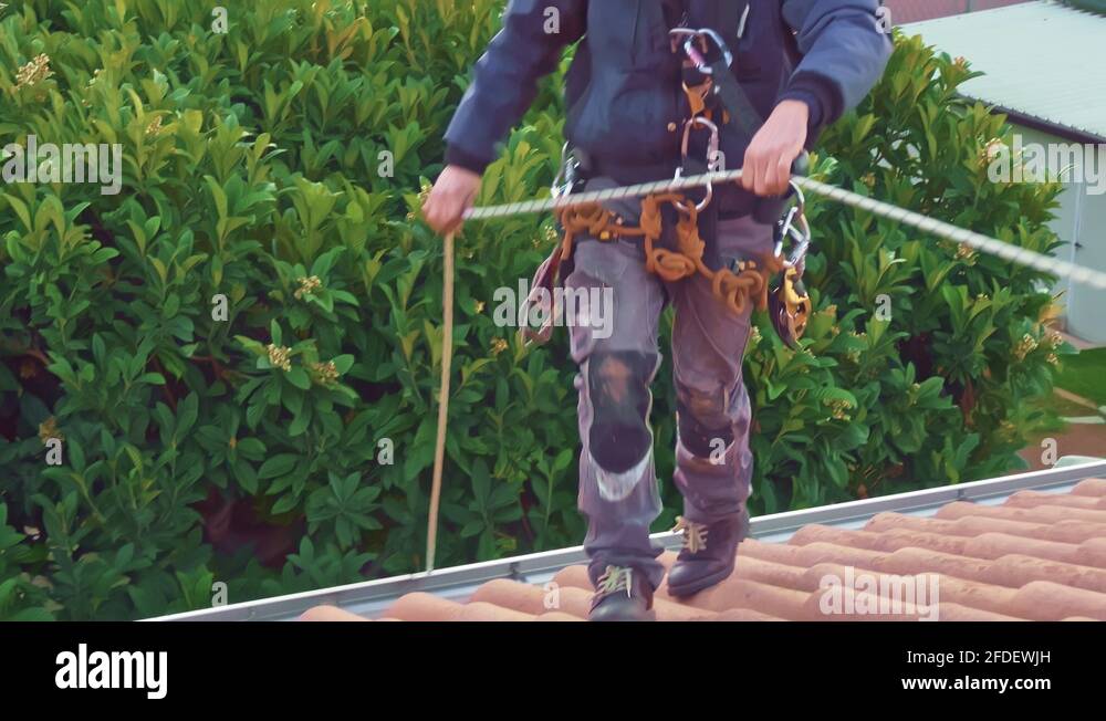 Rope access engineer wearing full body safety harness hardhat doing ...