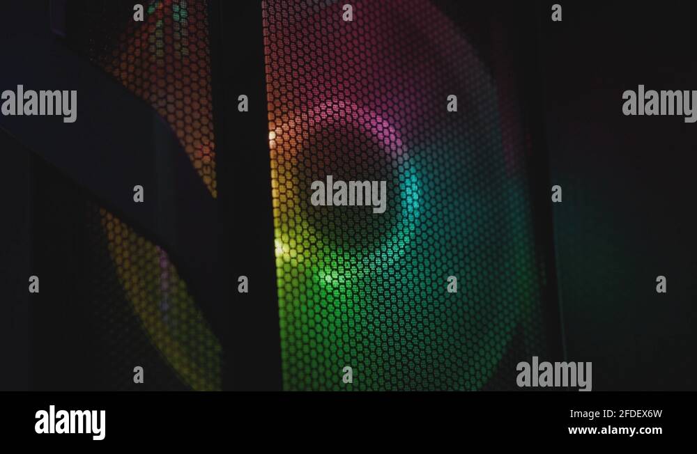 Rotating computer fans inside a black metal mesh shift color over an ...