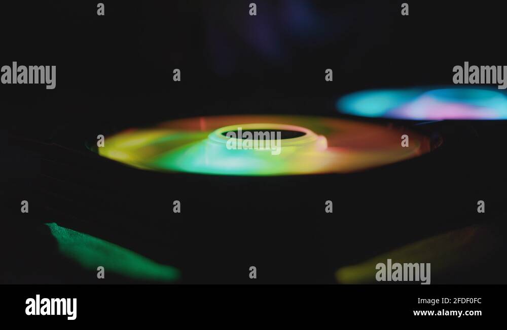 Low shot of rotating computer fan shifting colors in RGB spectrum ...