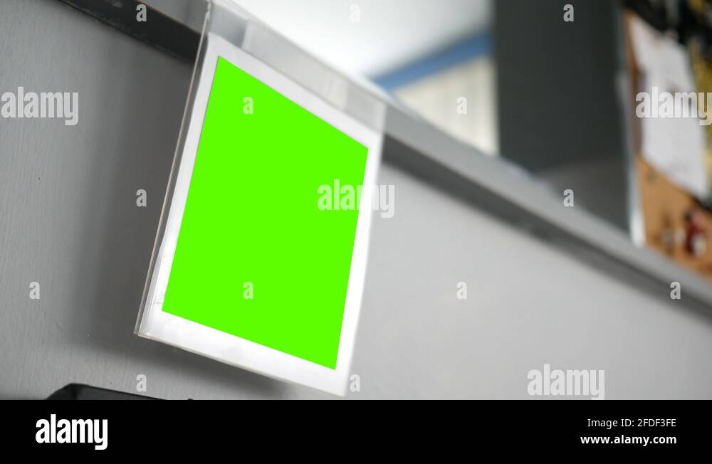 A generic green screen picture hanging down near mirror on countertop ...