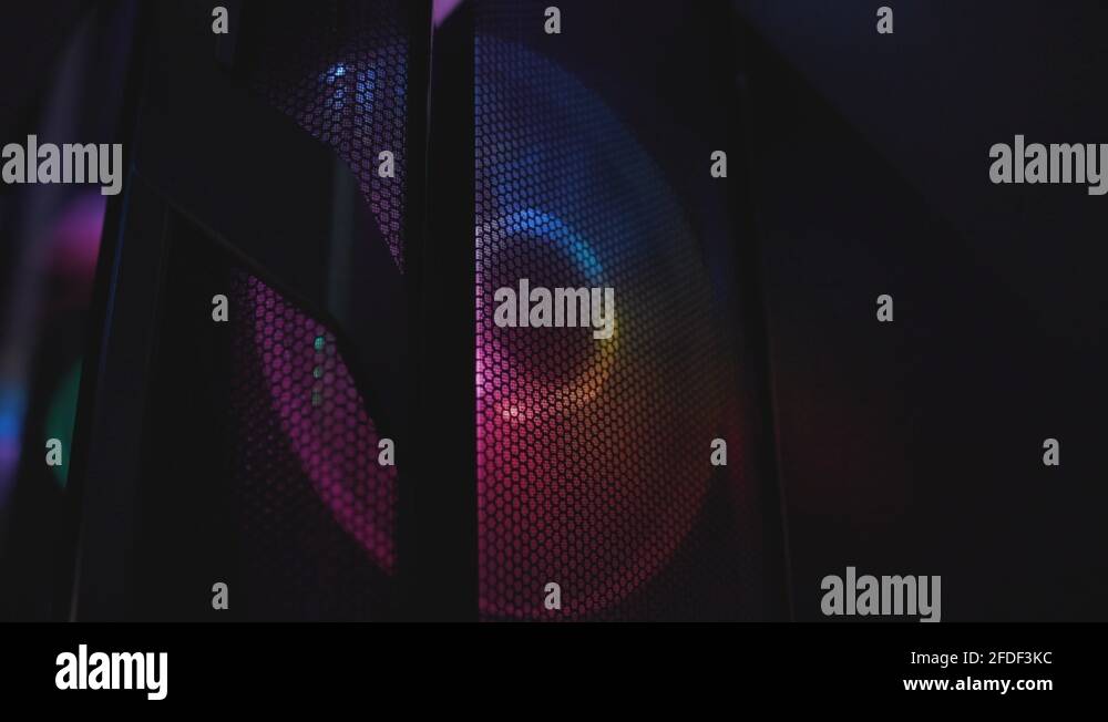 Rotating computer fans inside a black metal mesh shift color over an ...