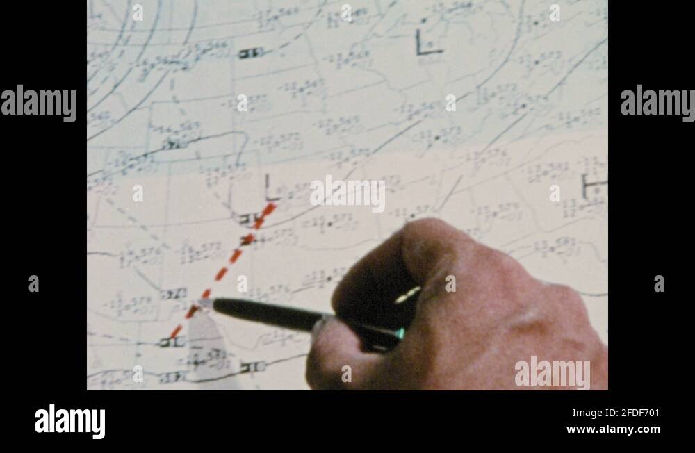 1970s: Man points at line on weather map. Man looking at map. Hands on ...