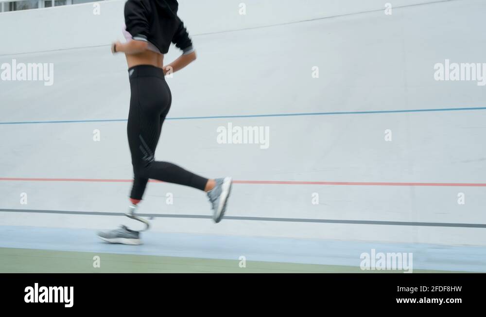 Disabled woman jogging on running track. Athlete legs running at sports ...