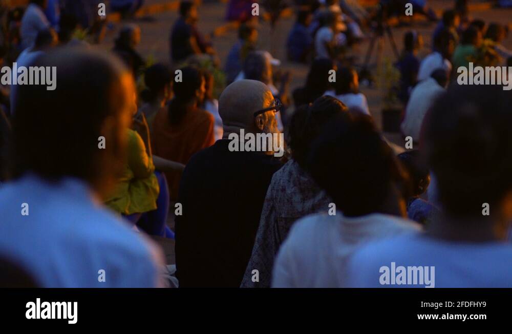 Many people sit in amphitheater watch bonfire, Matrimandir, Auroville ...