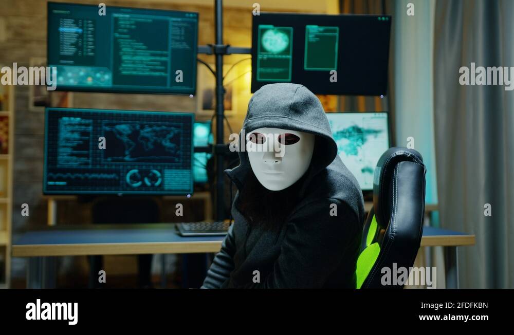 Masked hacker wearing a hoodie to hide his identity Stock Video Footage ...