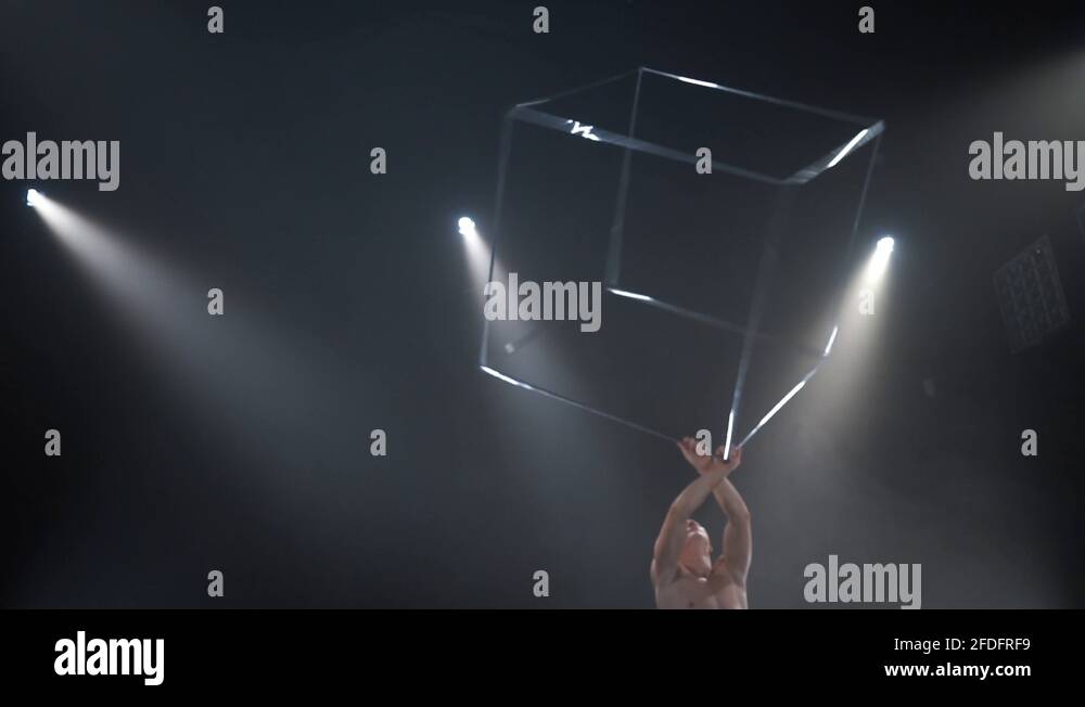 circus male muscular performer making tricks with juggling cube props ...