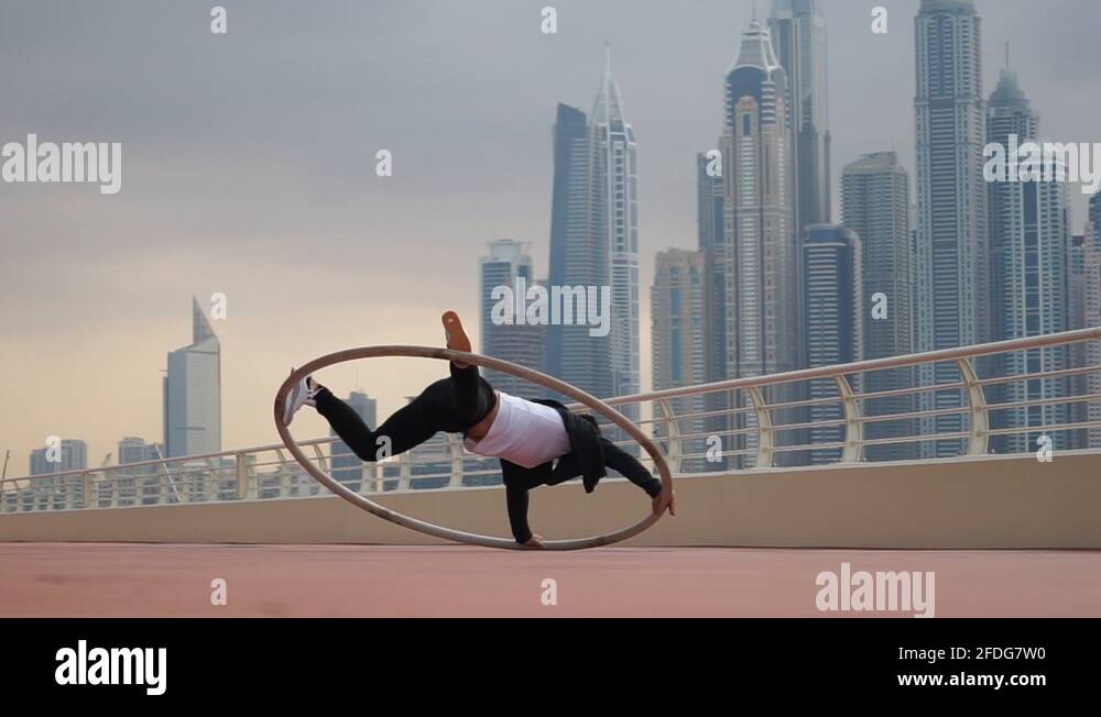 Cyr Wheel artist wearing black and white smart clothes with cityscape ...