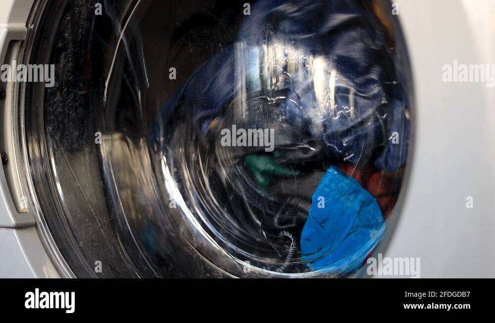 Washing Clothes. Laundromat Clothes tumble washing in machine close up ...